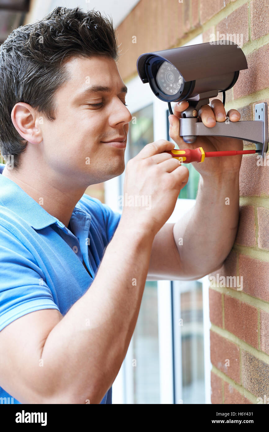 Security Consultant Fitting Camera To House Wall Stock Photo - Alamy