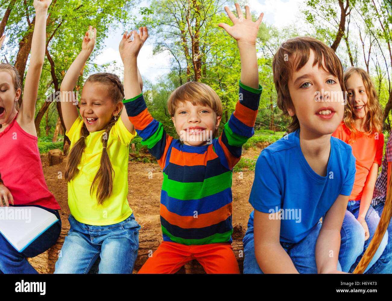 Smiling kids in summer forest with their hands up Stock Photo - Alamy