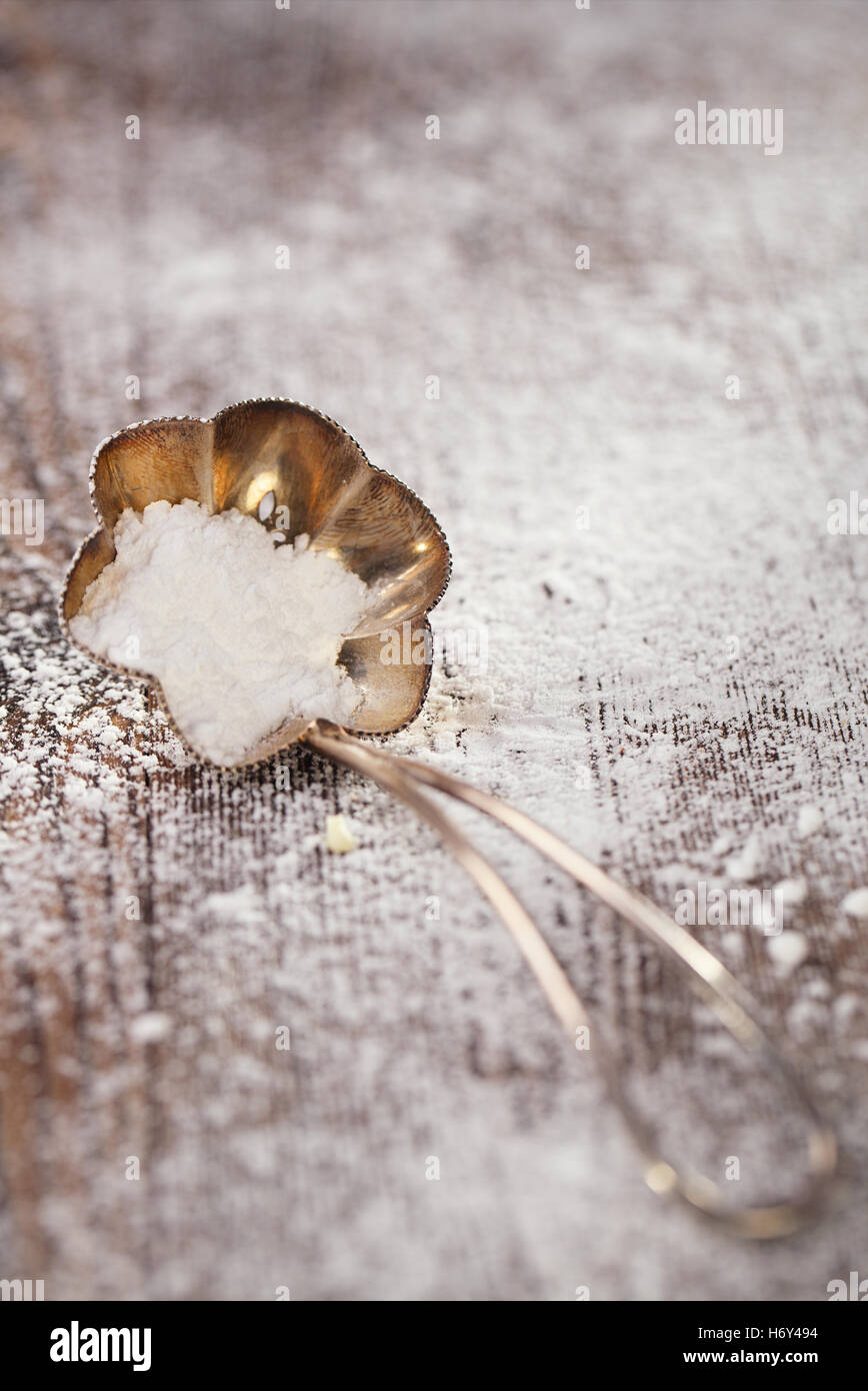 vintage sieve silver spoon with sugar powder and wooden backdrop Stock ...