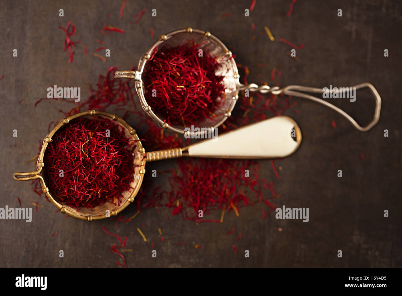saffron spice threads and powder in vintage old sieve, old metal ...