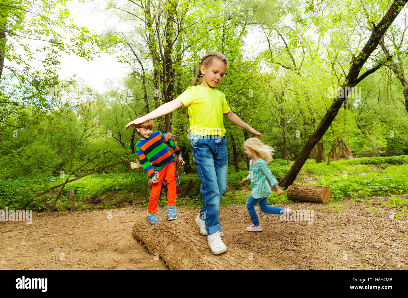 Kids standing on a log and balancing in the forest Stock Photo - Alamy