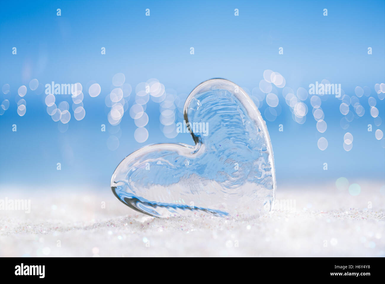 clear glass heart on white glitter and blue abstract background Stock ...