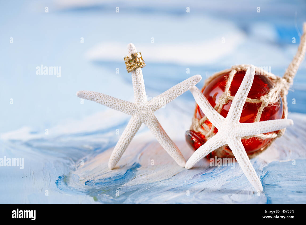 white starfish with red Glass float on blue painted background Stock ...