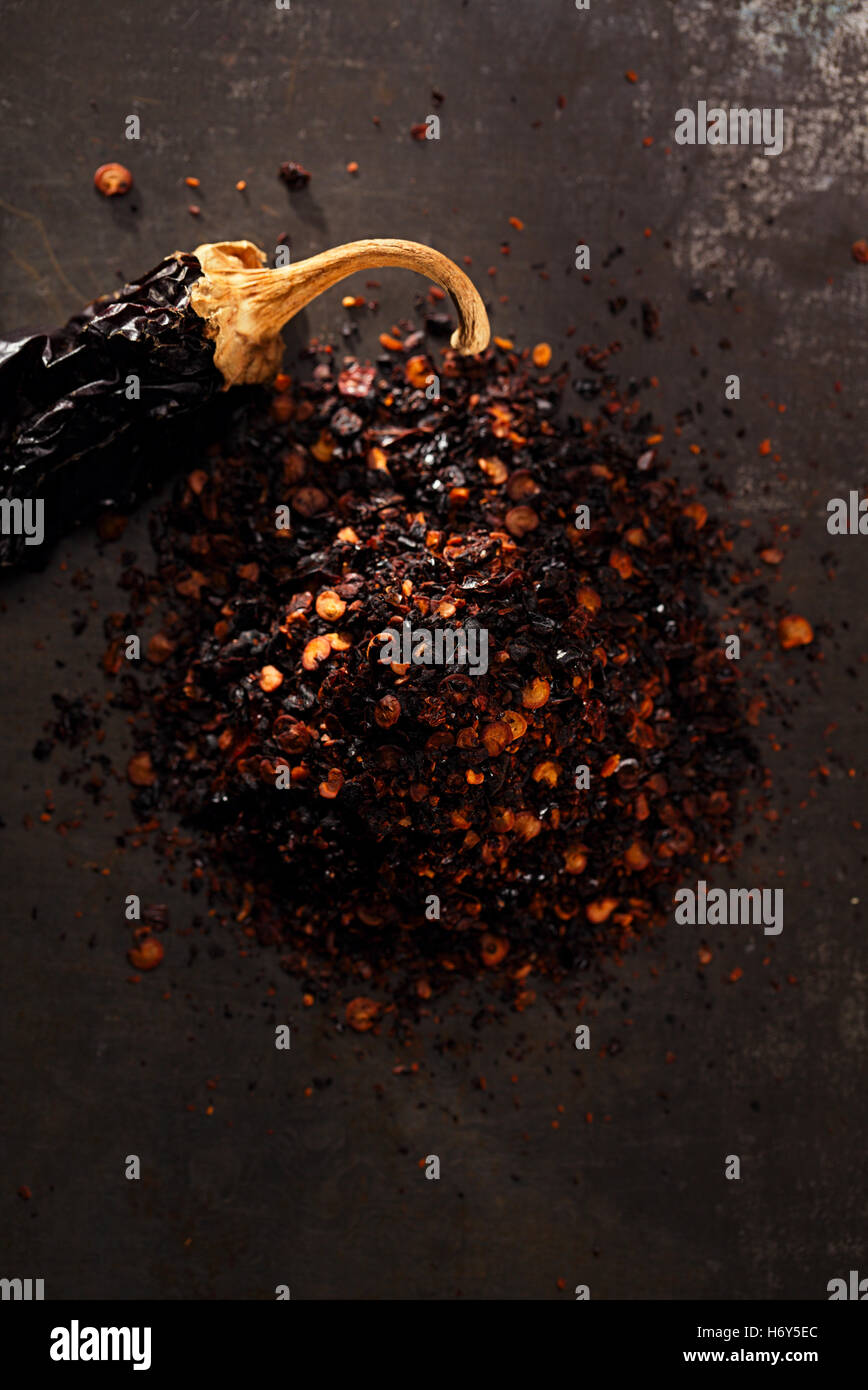 chipotle - jalapeno smoked chili flakes and whole on metal background ...