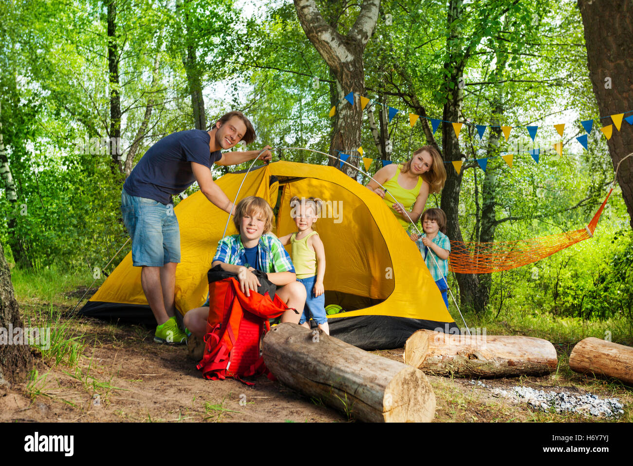 Happy family putting up a tent on camping trip Stock Photo - Alamy