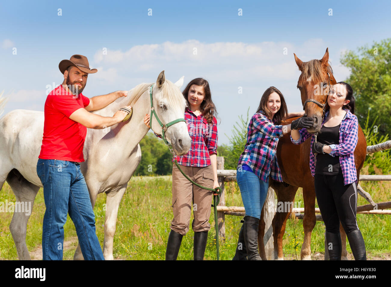 Group of four horseback riders with their horses Stock Photo - Alamy