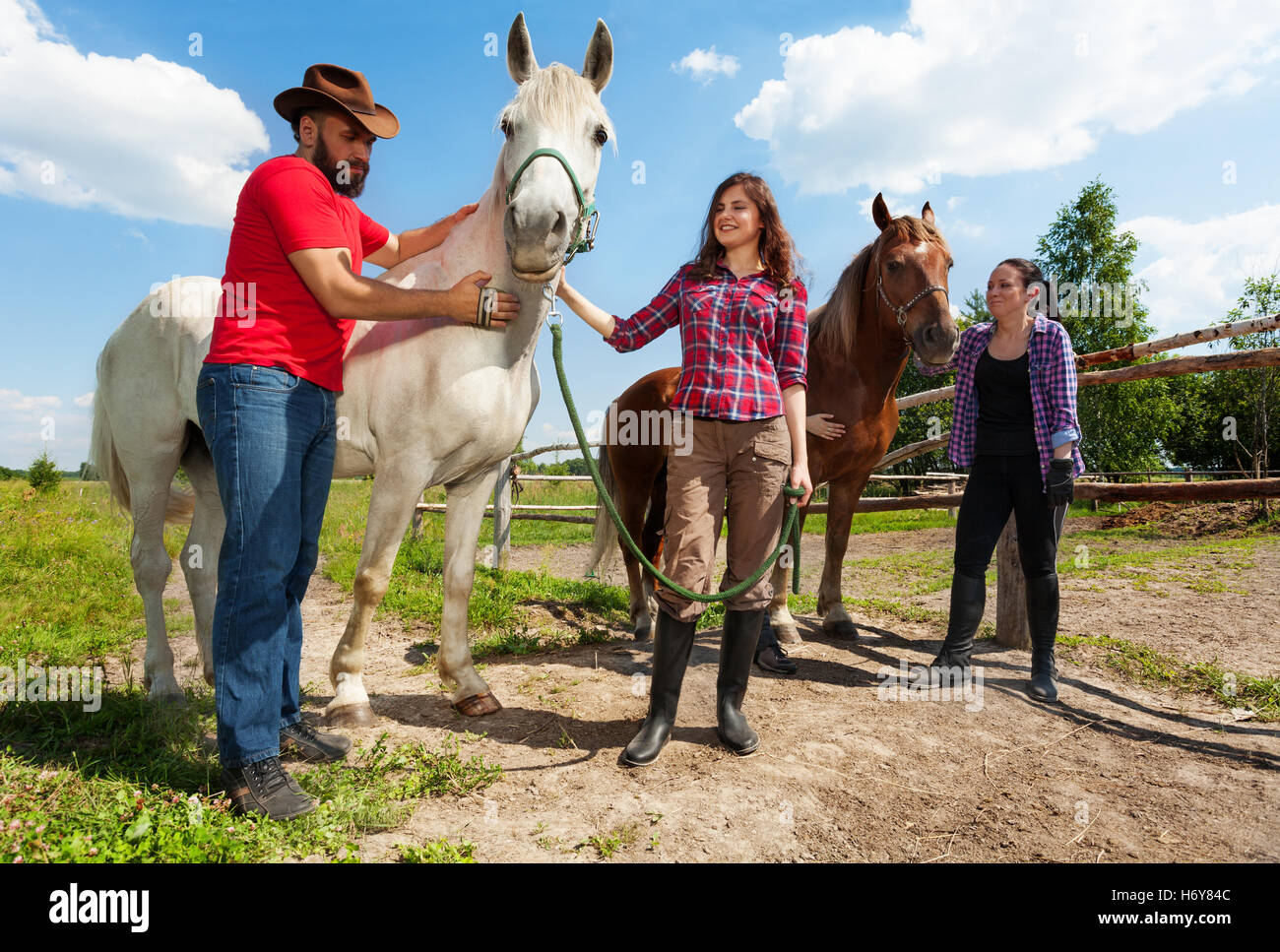 Happy horseback riders having rest at the paddock Stock Photo - Alamy