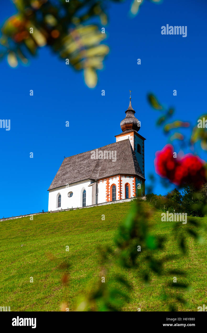 Beautiful little church in Alps. Sunny day, green grass on the hill and ...