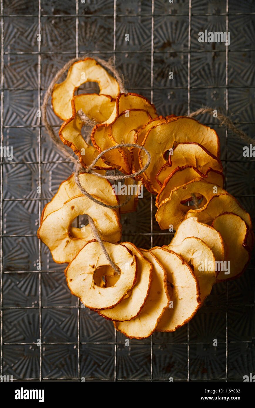 Dried apple slices hanging on string with dark metal backdrop Stock ...