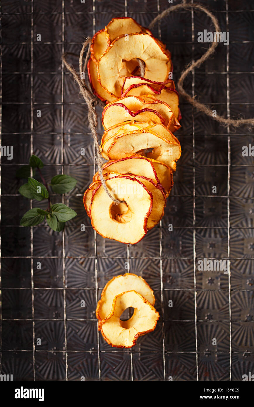 Dried apple slices hanging on string with dark metal backdrop Stock ...