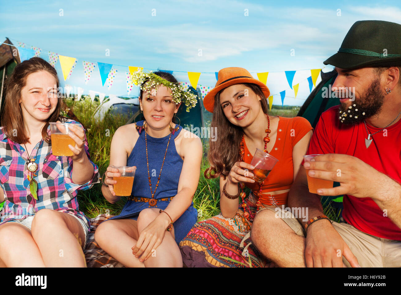 Happy friends drinking outside tents at campsite Stock Photo - Alamy