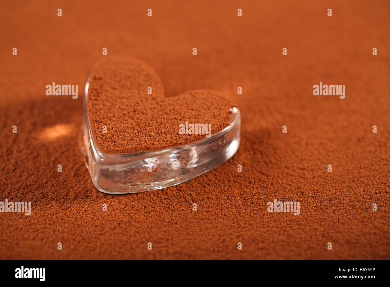cocoa chocolate powder with dusted heart shaped glass, perfect color ...