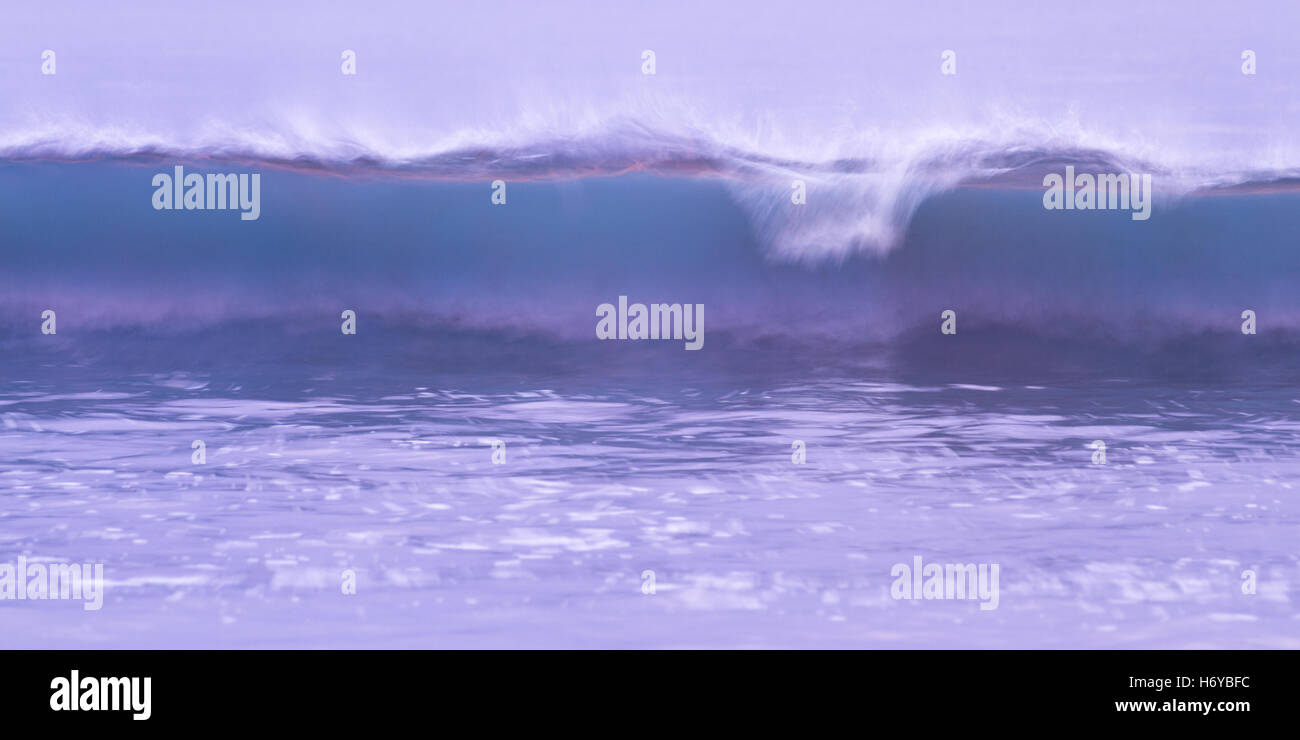 sunset glow used for lighting with a slow shutter speed on moving waves ...