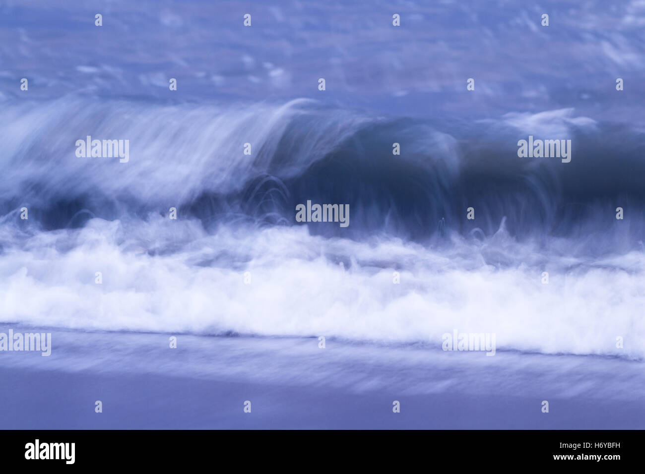 sunset glow used for lighting with a slow shutter speed on moving waves ...