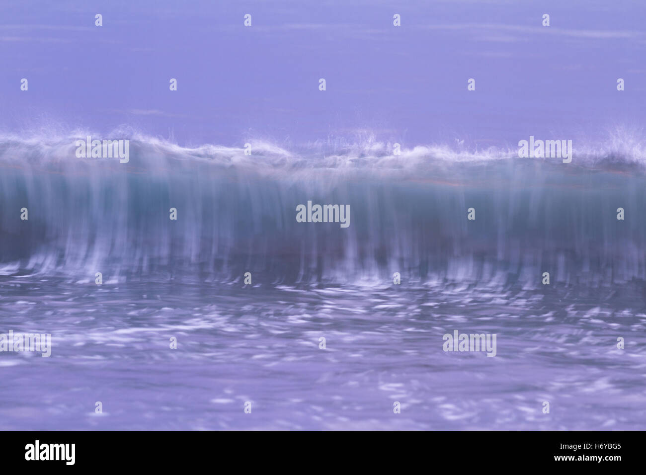 sunset glow used for lighting with a slow shutter speed on moving waves ...