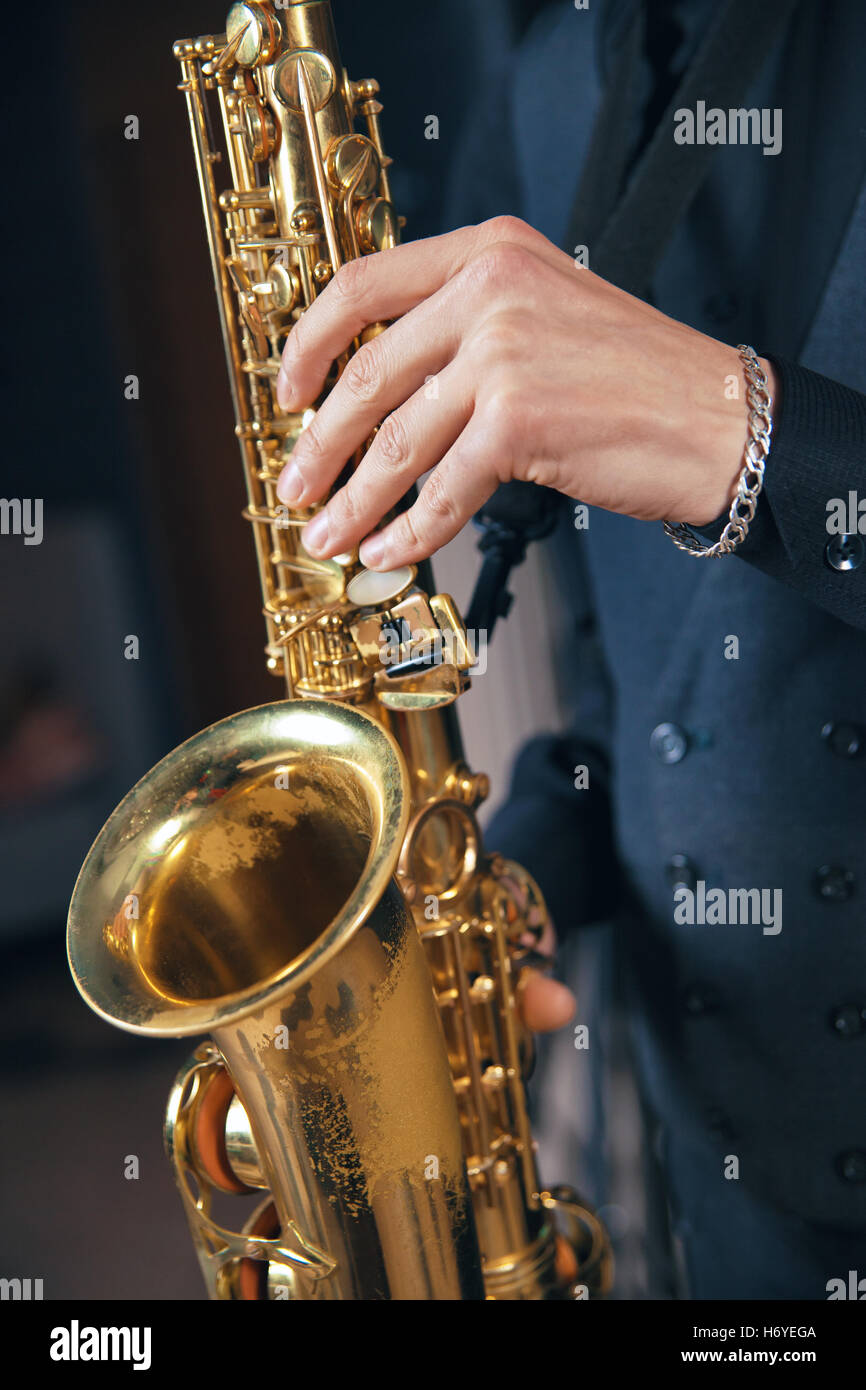 Young man in a suit hold saxophone Stock Photo - Alamy
