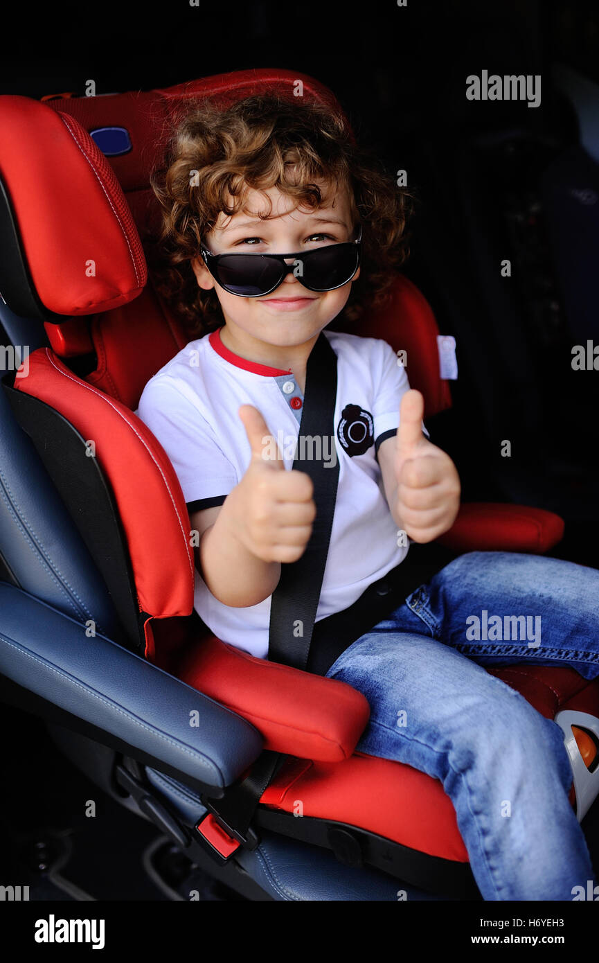 baby boy sitting in a red child car seat Stock Photo - Alamy