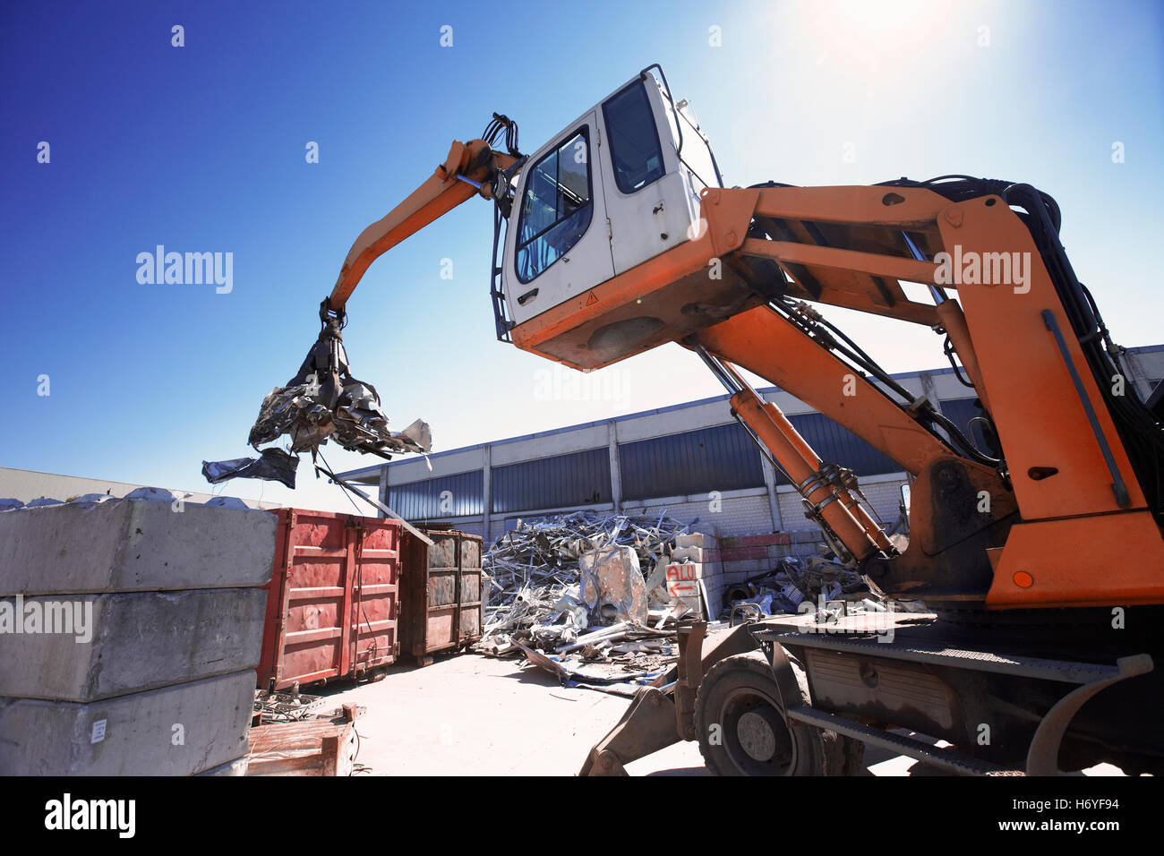 Grapple handler sorting and moving metals in scrap yard Image ...
