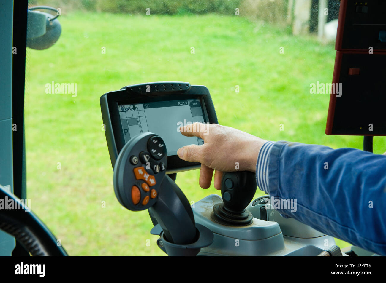 Hand of farmer using computer touchscreen in tractor Stock Photo - Alamy