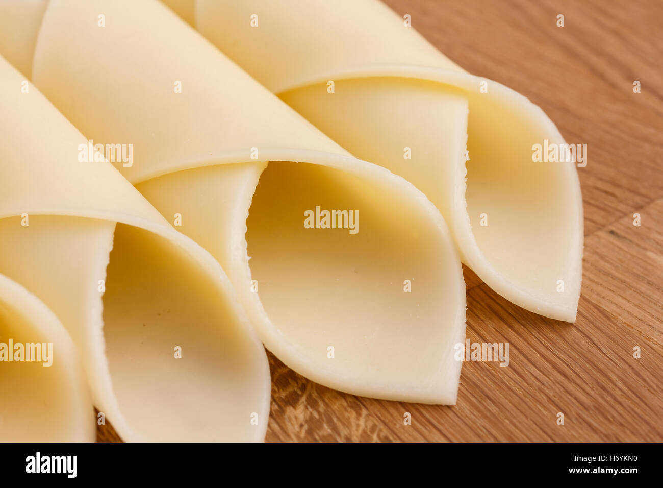 Wrapped yellow cheese slices arranged on a wood surface Stock Photo - Alamy