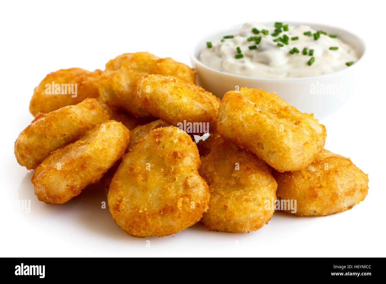 Pile of golden deep-fried battered chicken nuggets with bowl of tartar ...