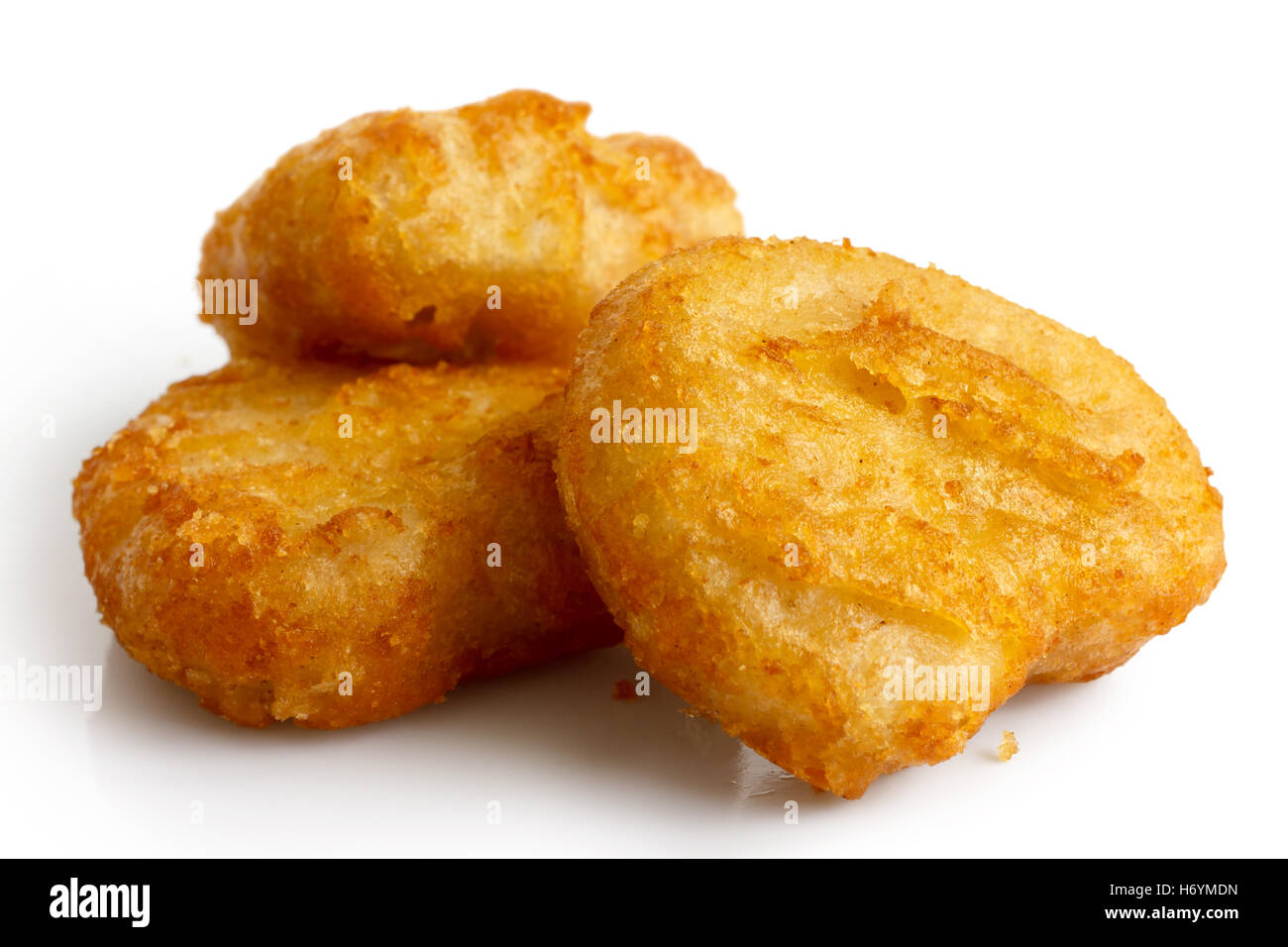 Three golden deep-fried battered chicken nuggets isolated on white in ...