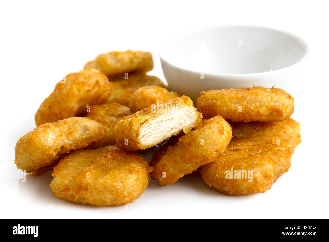 Pile of golden deep-fried battered chicken nuggets with empty bowl ...