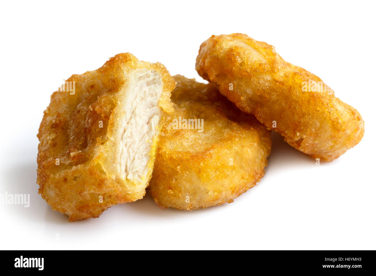 Three golden deep-fried battered chicken nuggets isolated on white in ...