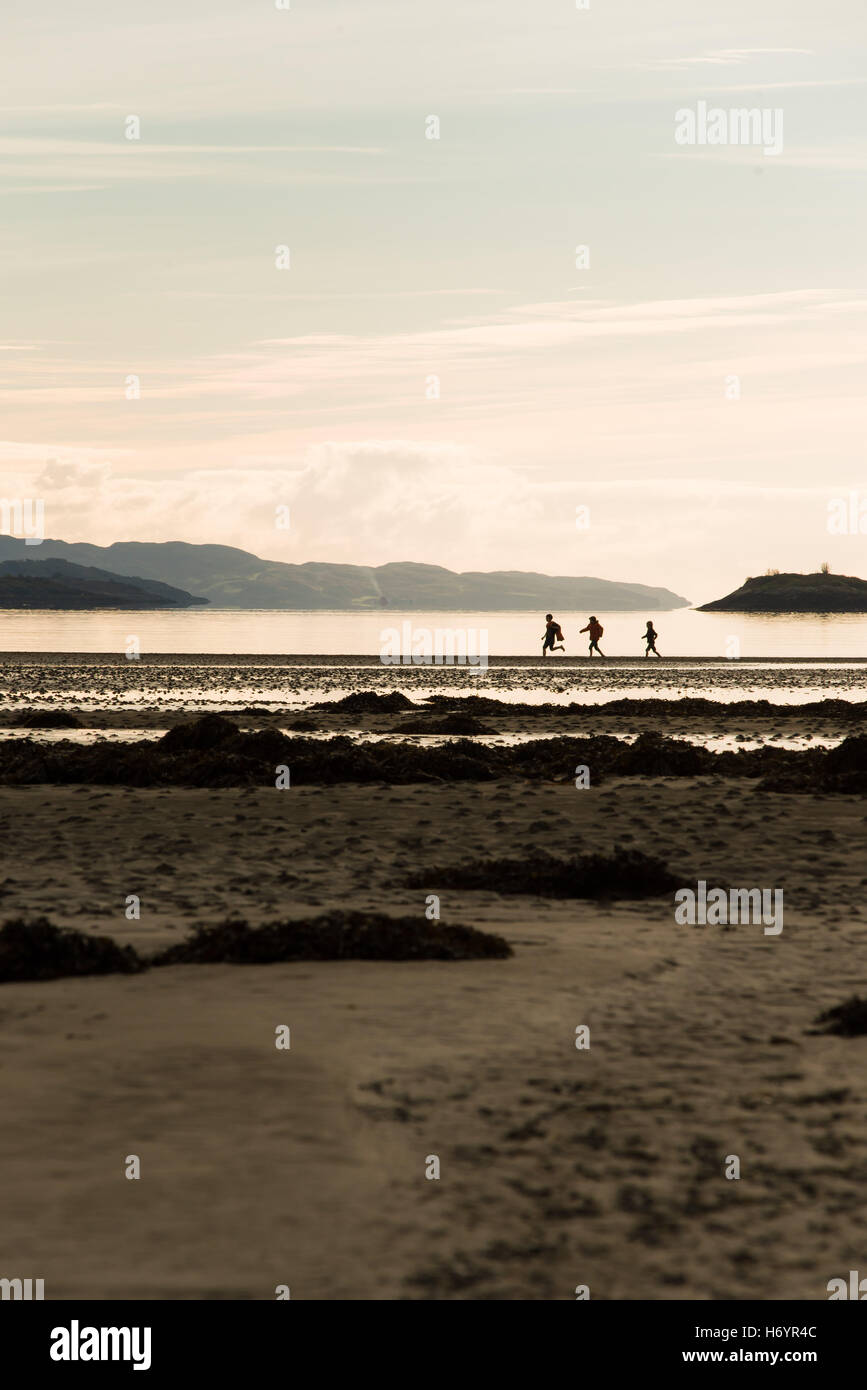 children running down beach in silhouette Stock Photo - Alamy