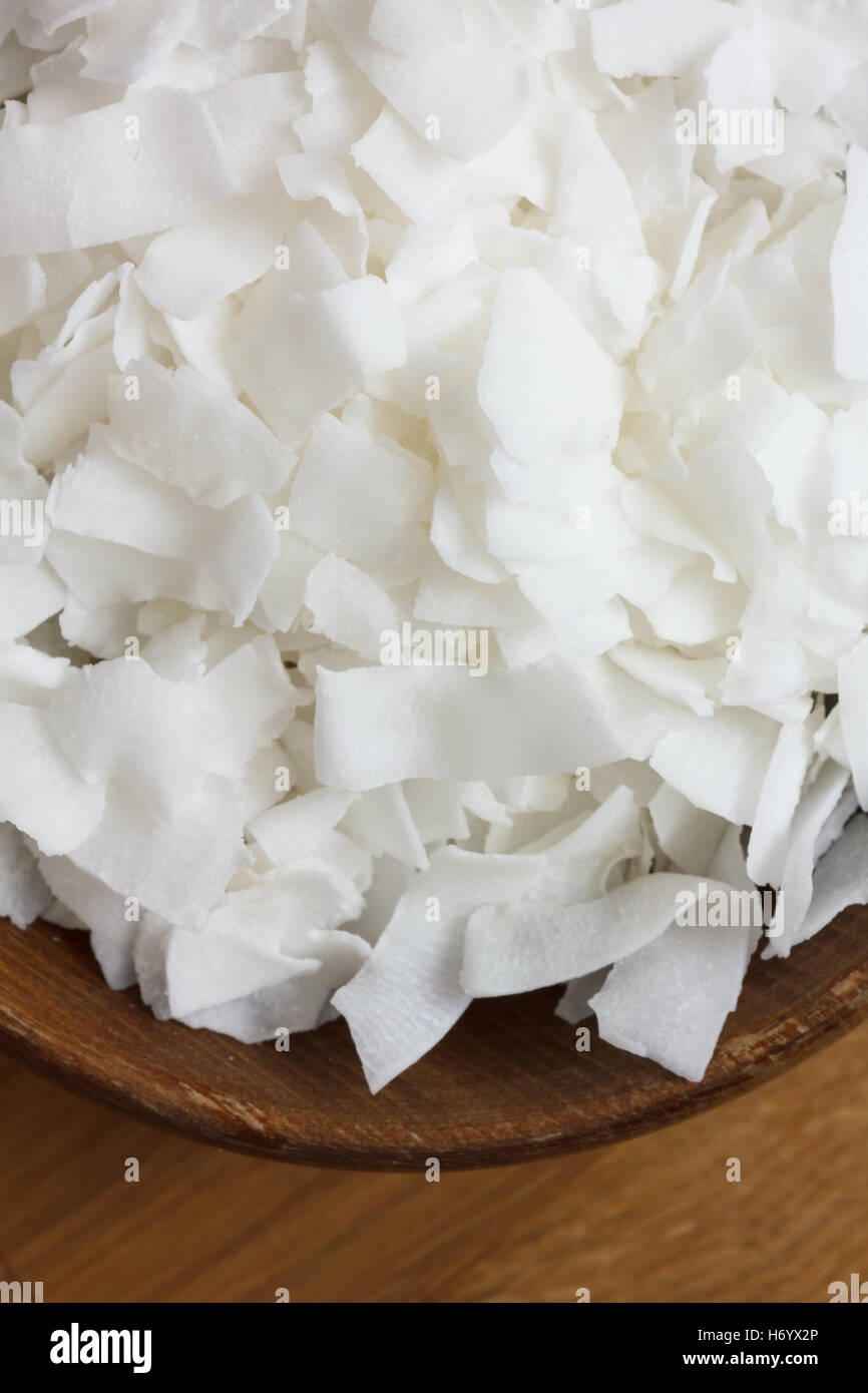 Dark wood bowl of shaved coconut on wood table Stock Photo - Alamy