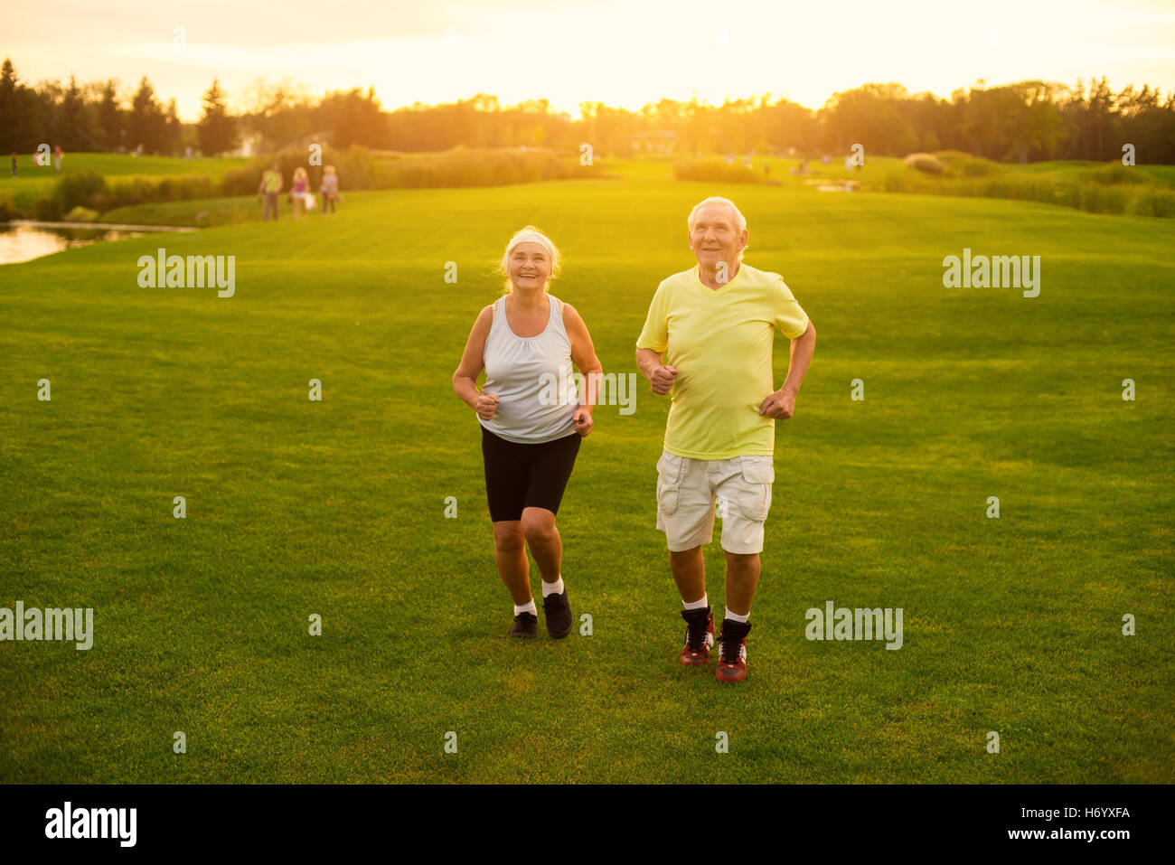 Couple jogging on grass Stock Photo - Alamy
