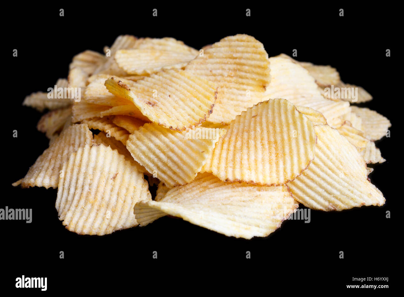 Ridged fried potato crisps on black Stock Photo - Alamy