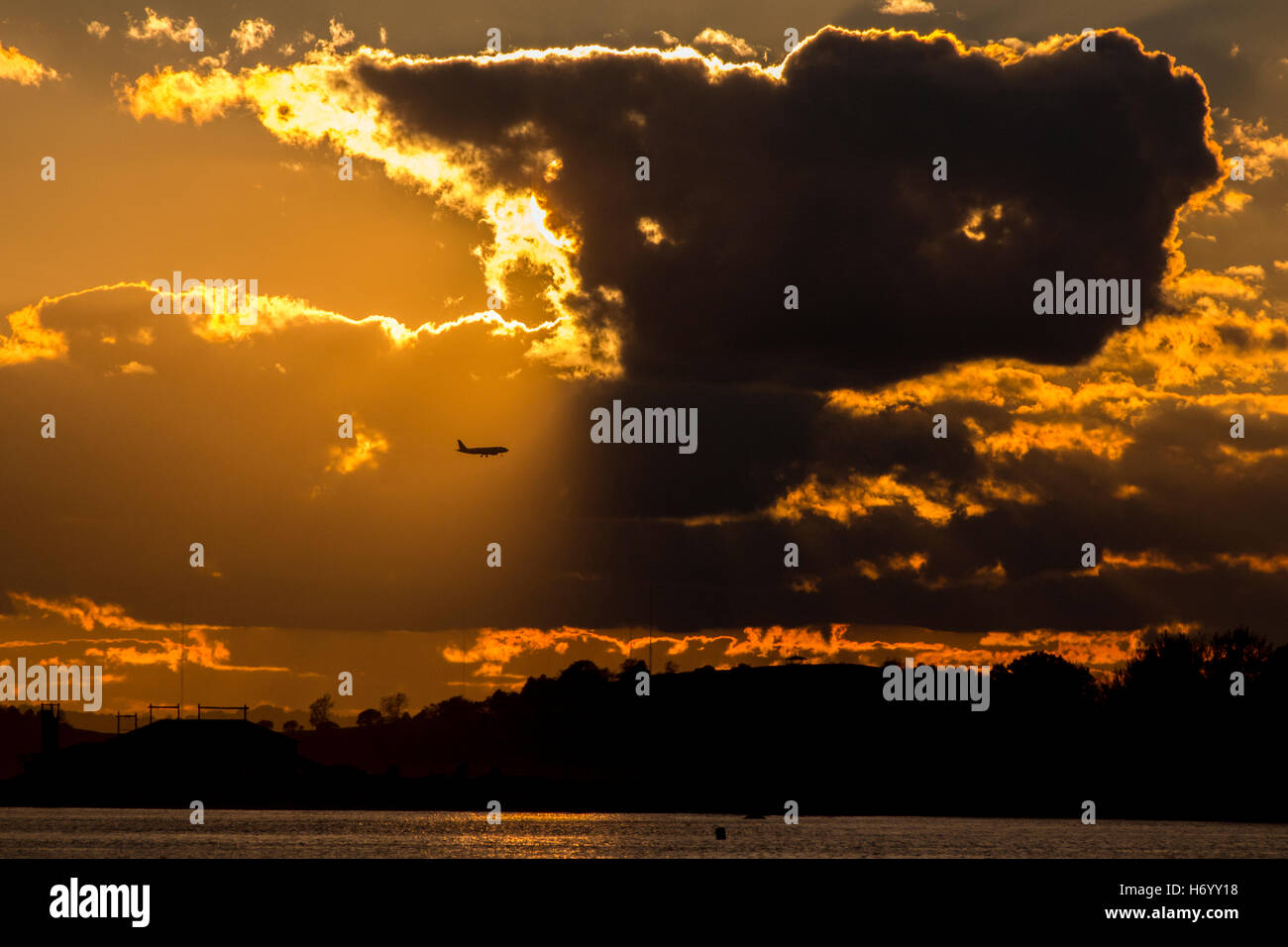 Massachusetts, Boston. Jet flying into Boston Logan airport at sunset ...
