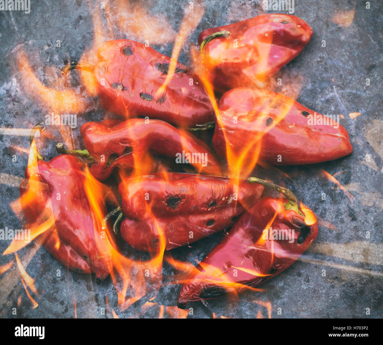 Roasted red peppers in flame on the barbecue, double exposure ...