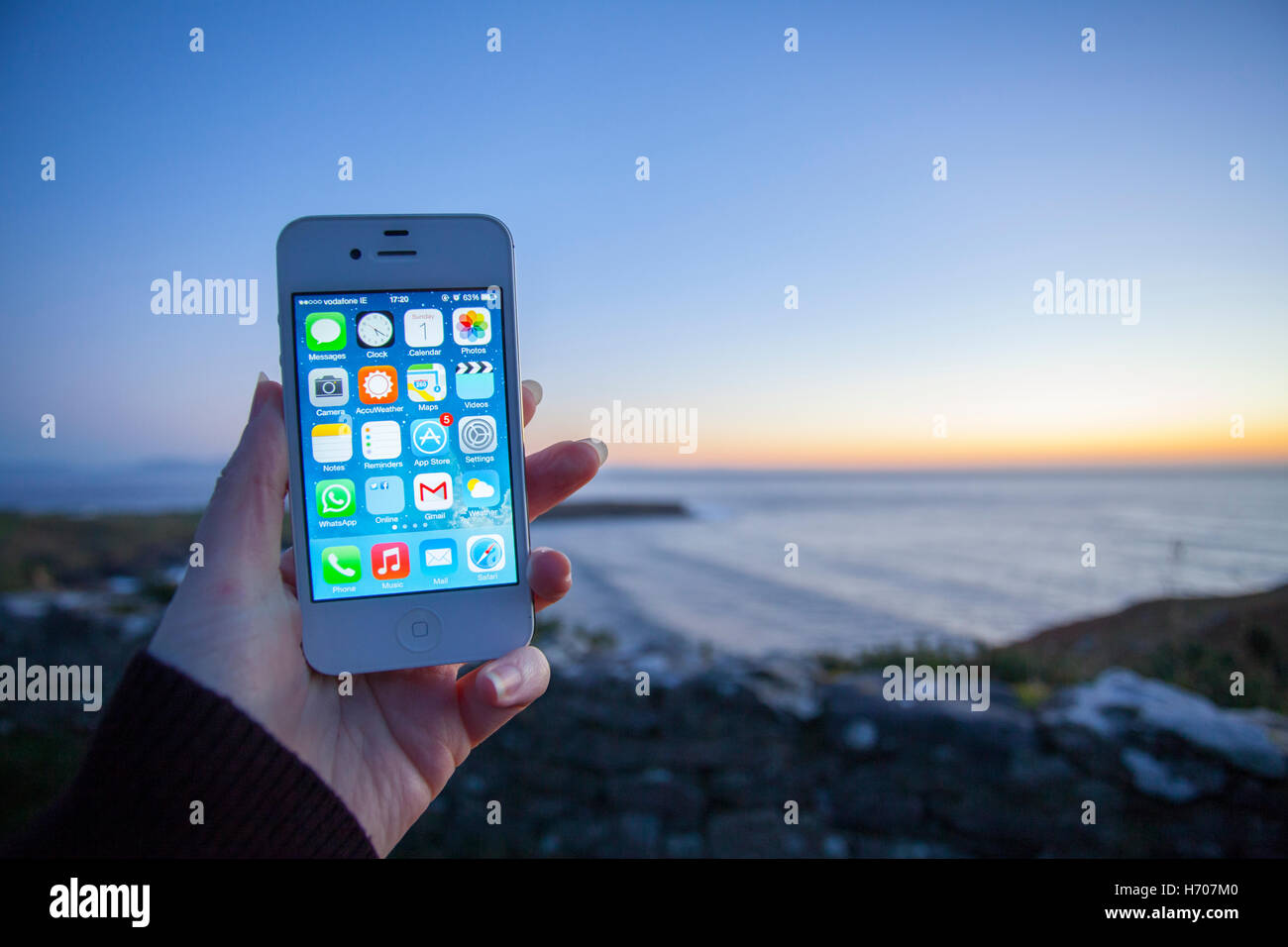 Hands using a smart phone to take a photograph of a landscape at ...