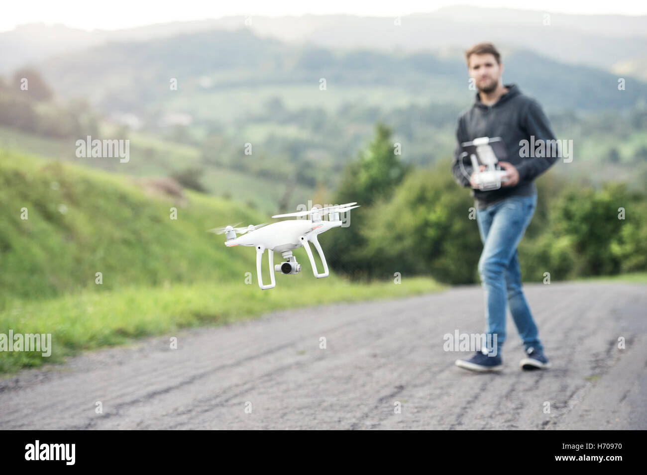 Young hipster man with flying drone. Sunny green nature Stock Photo - Alamy