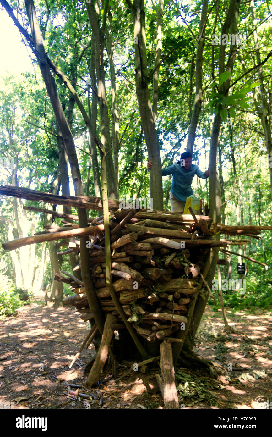 Young woman climbing a tree house structure set in woods, Jimmy's Farm ...