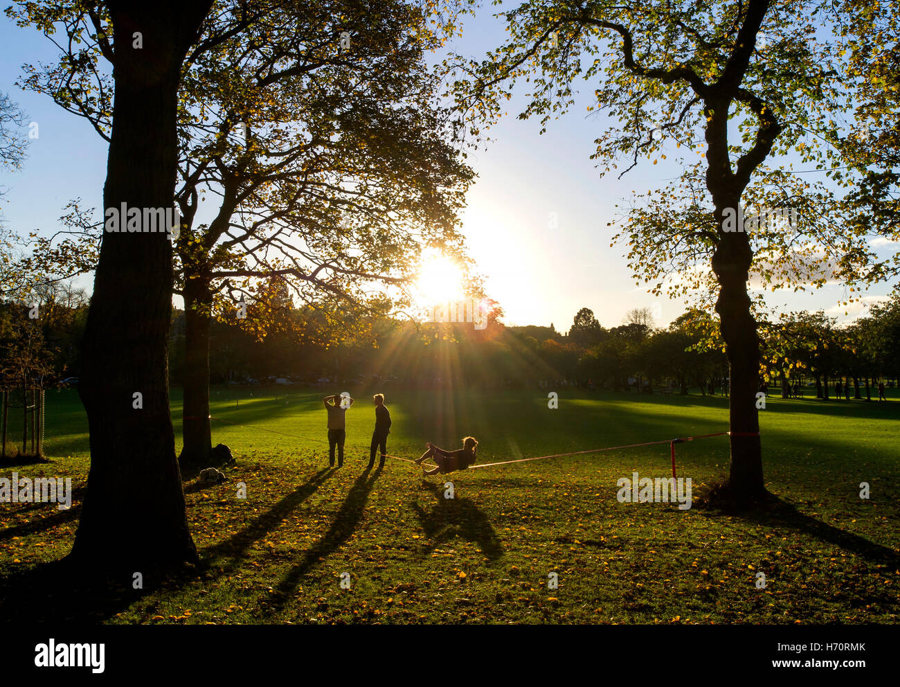 The Meadows, Edinburgh, Scotland. The low autumn sunlight casts long ...