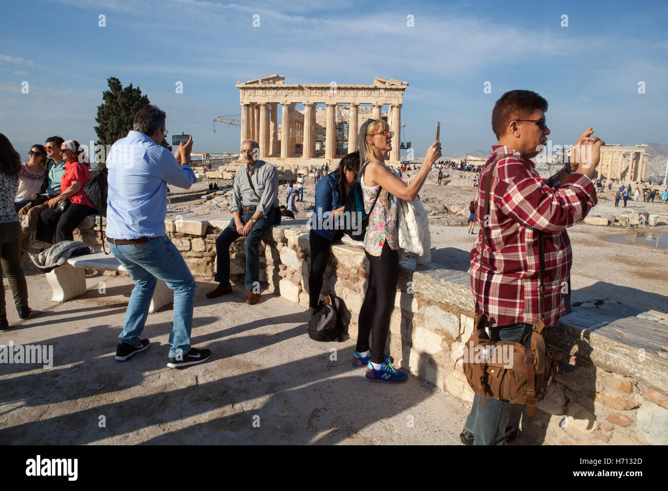 Tourists take photographs in front of the Parthenon at the Acropolis in ...