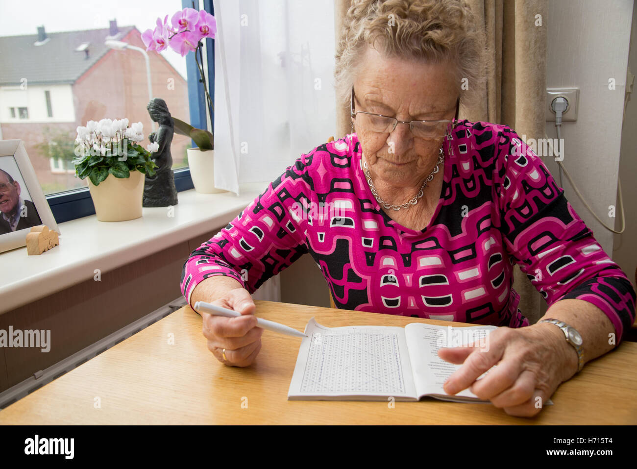 old woman puzzling at table Stock Photo - Alamy