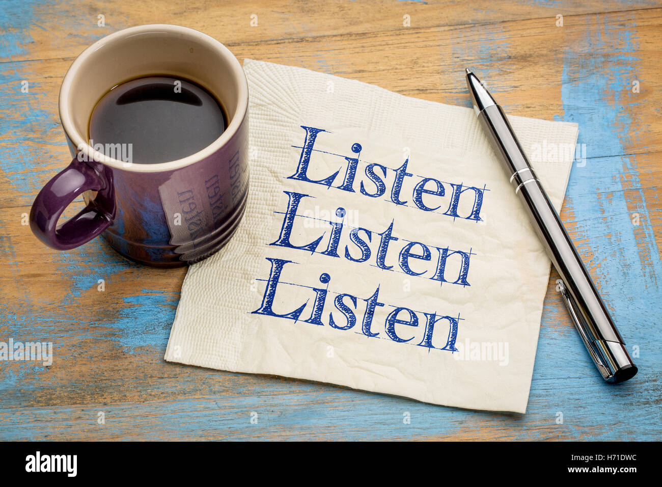 Listen - communication concept - handwriting on a napkin with a cup of ...