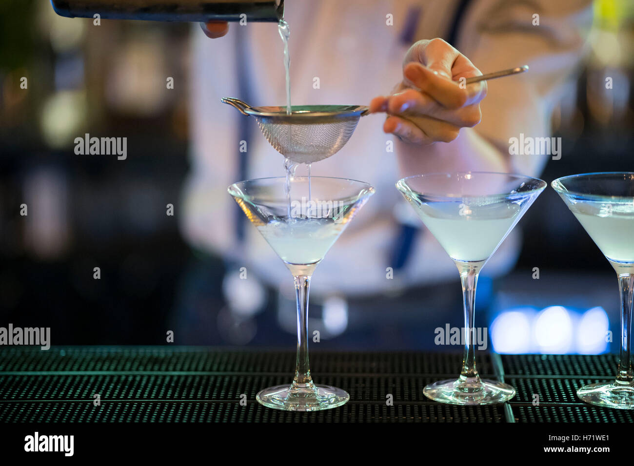 A cocktail maker barman making martinis and cocktails at a bar Stock ...