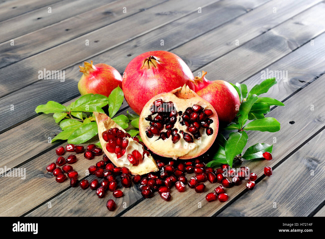 Closeup of ripe pomegranate fruit and seeds on an antique wooden base ...