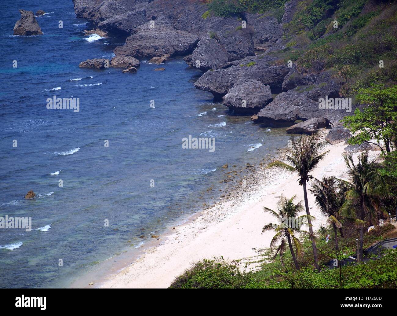 A secluded beach with fine sand, blue water and palm trees Stock Photo ...