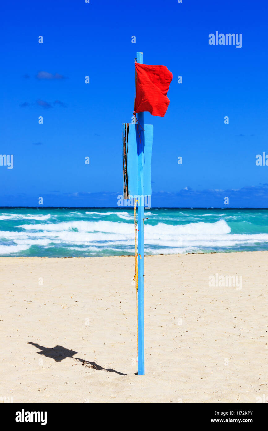 red flag on the beach during a storm Stock Photo - Alamy