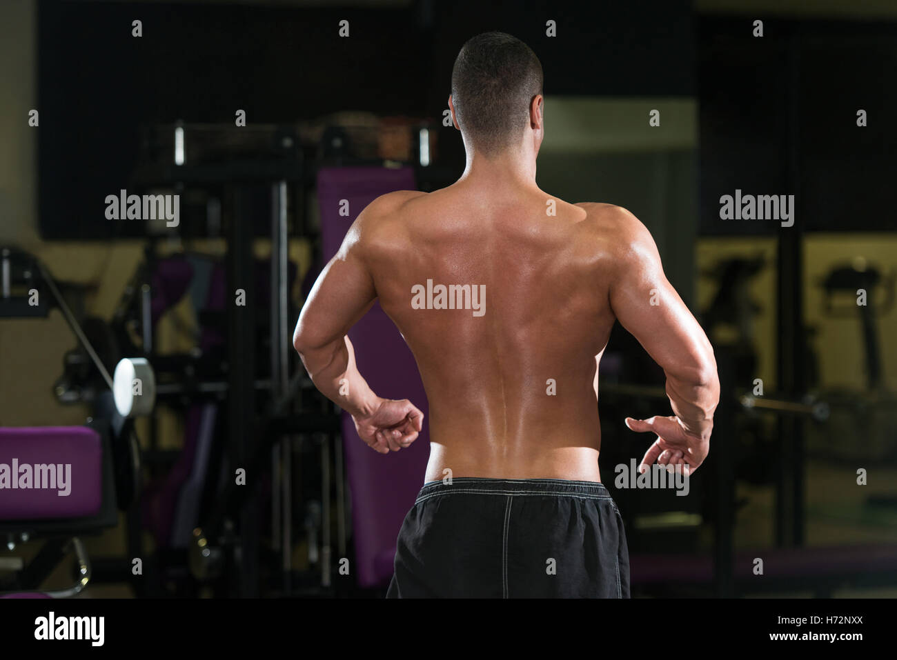Young Man Standing Strong In The Gym And Flexing Rear Lat Spread Pose ...