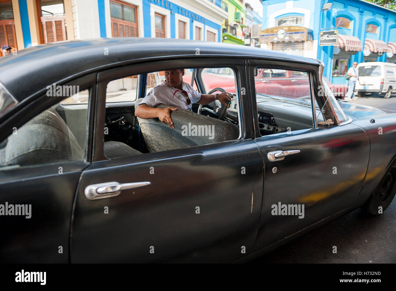 HAVANA - JUNE 17, 2011: Cuban taxi driver reverses his classic American ...