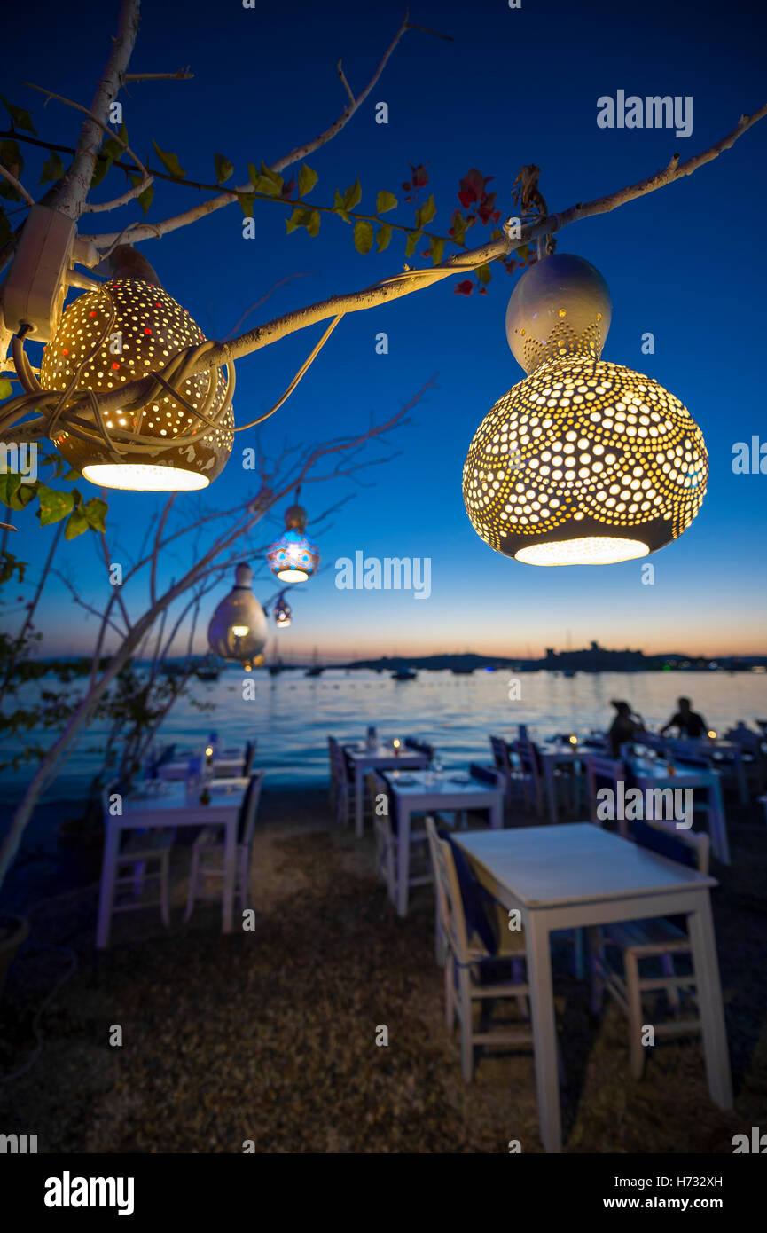 Informal beachside seating with decorative gourd lights hanging from a ...