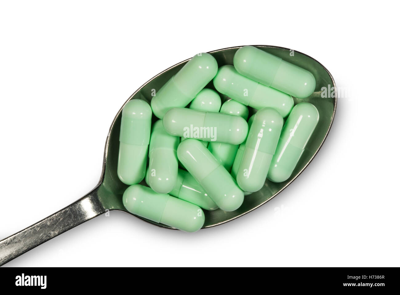 Capsule of medicine in a metal spoon on white background Stock Photo ...