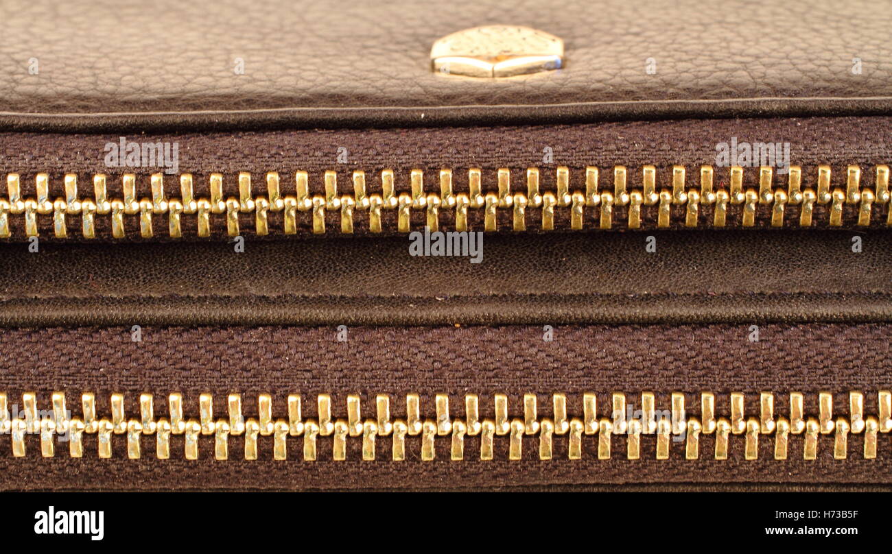 A bronze zipper in a brown pouch isolated up close conceptual image ...